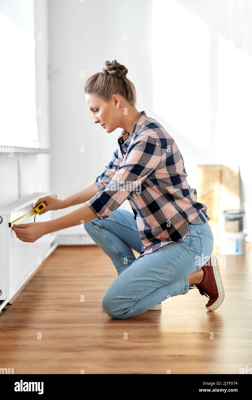 woman with ruler measuring heater at home Stock Photo - Alamy