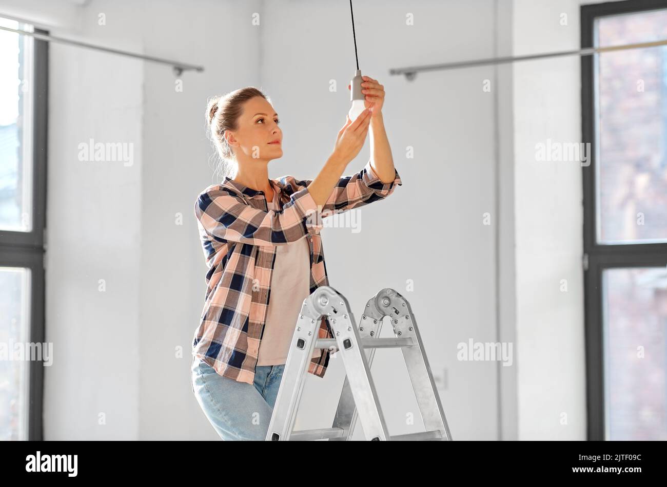 woman changing light bulb at new home Stock Photo - Alamy