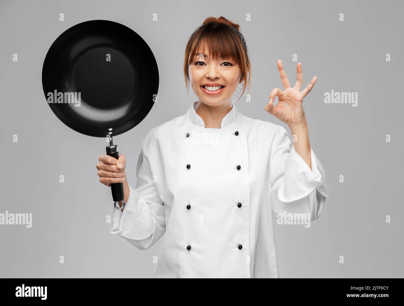 happy female chef with frying pan showing ok sign Stock Photo - Alamy