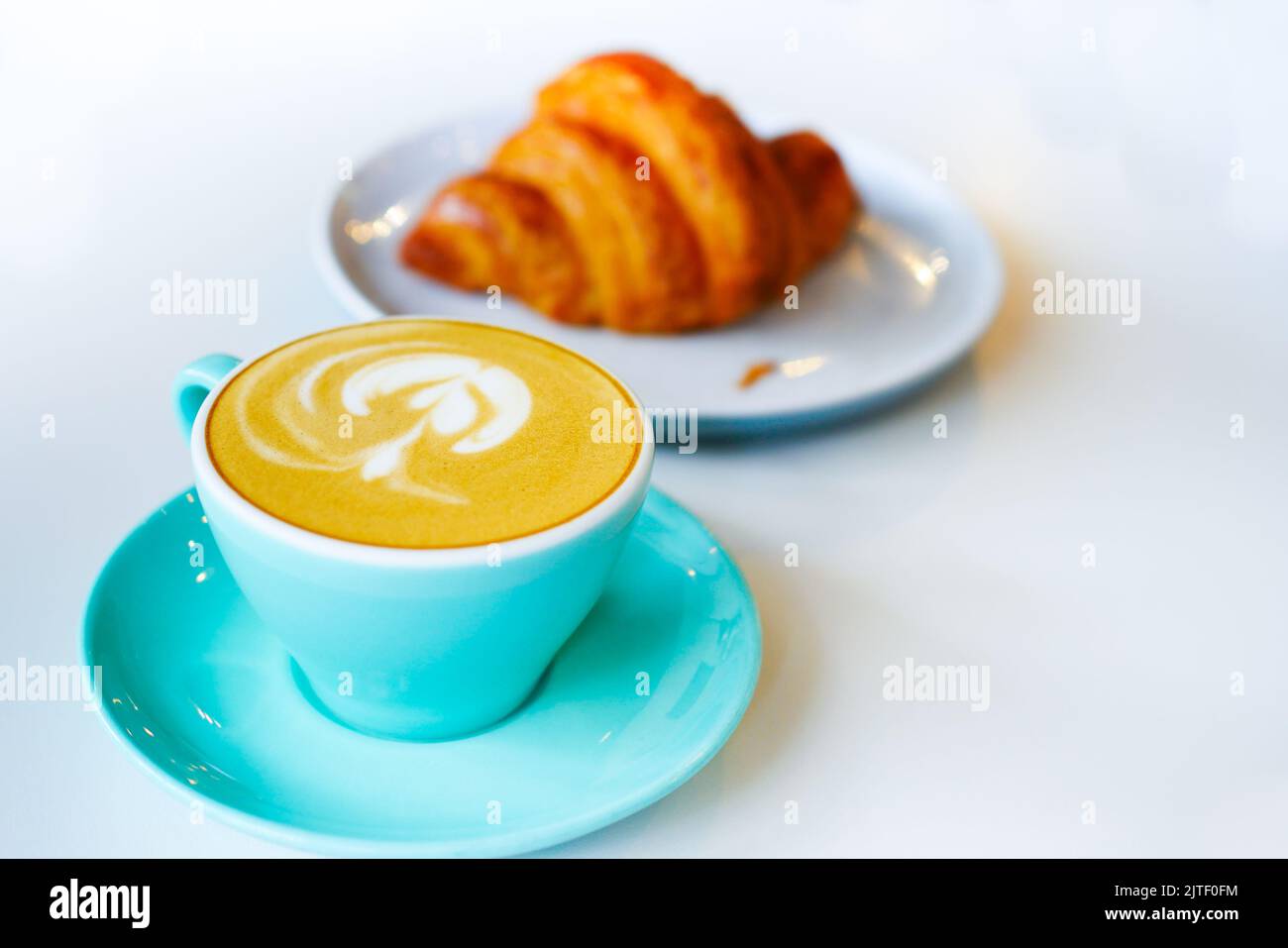 a green color cup of late coffee with flower shape design Stock Photo ...