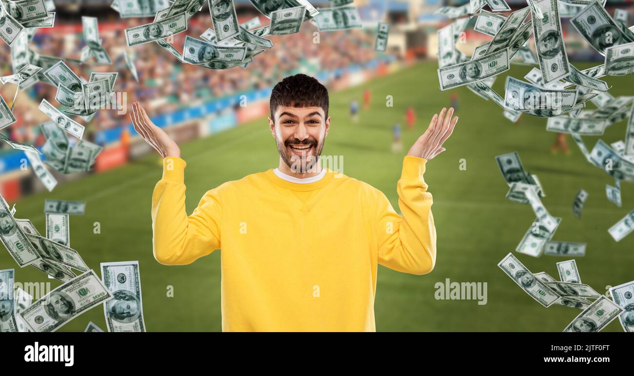 happy man with over money rain on football field Stock Photo - Alamy