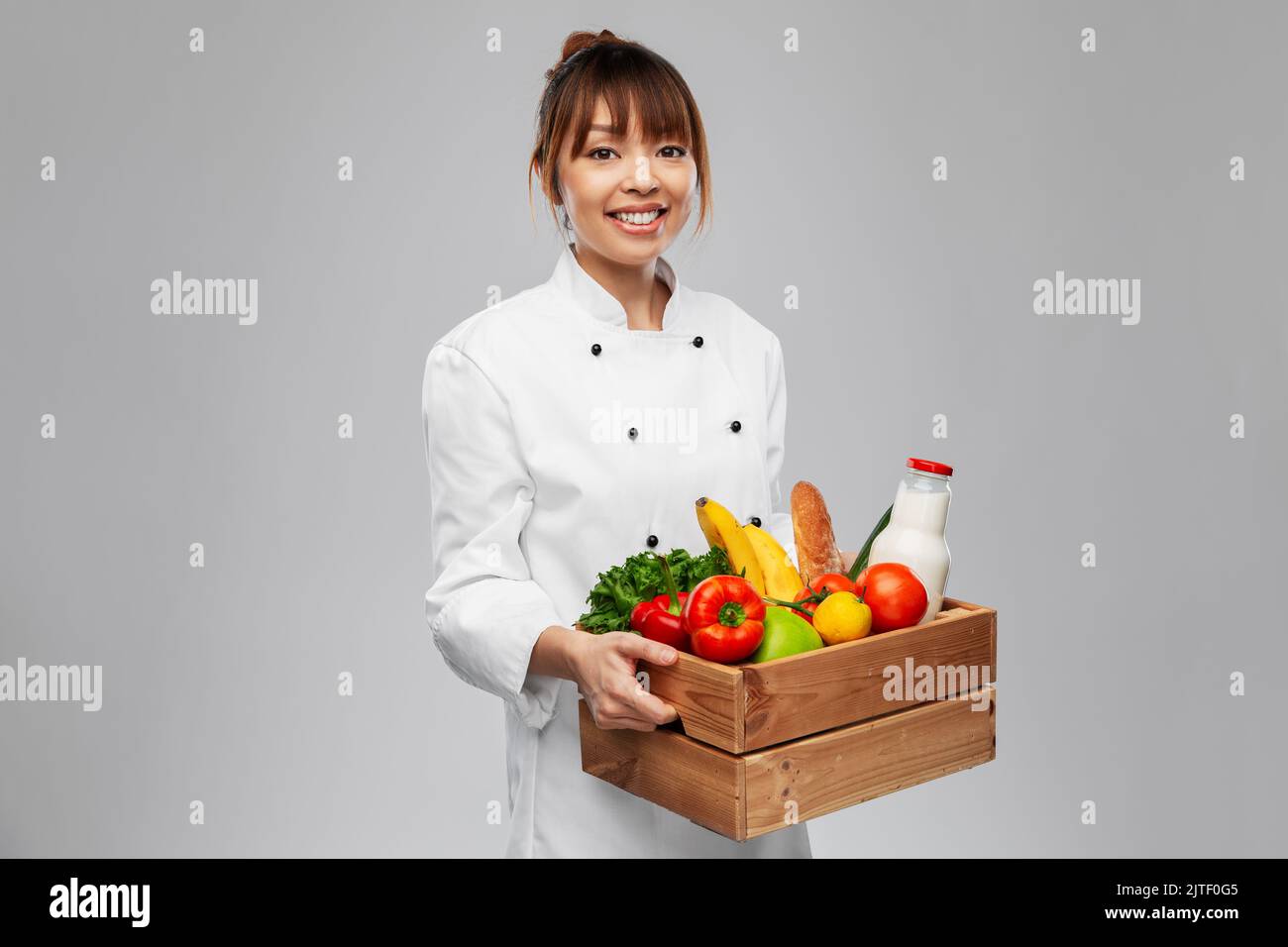 happy smiling female chef with food in wooden box Stock Photo - Alamy