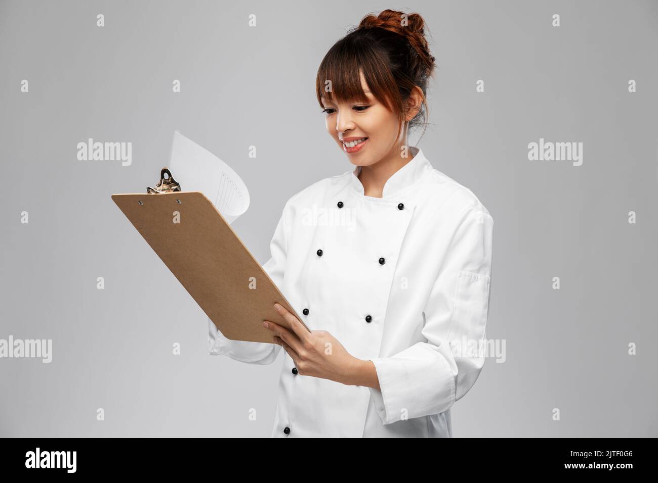 Smiling female chef clipboard hi-res stock photography and images - Alamy