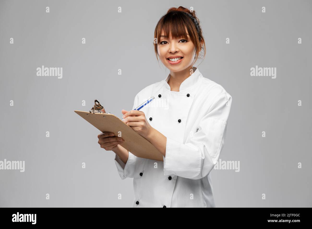 smiling female chef with clipboard and pen Stock Photo - Alamy