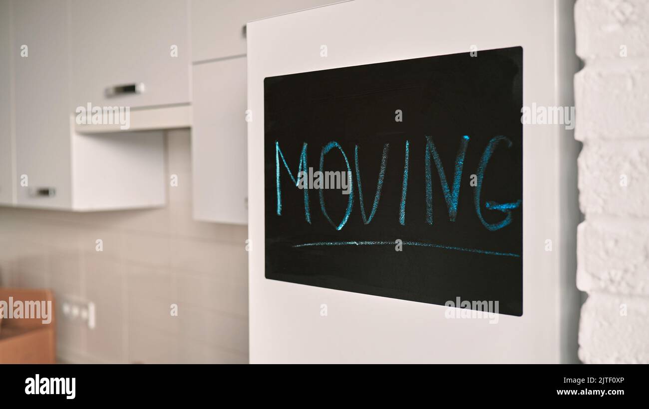 The word moving written in blue chalk on a small blackboard Stock Photo ...