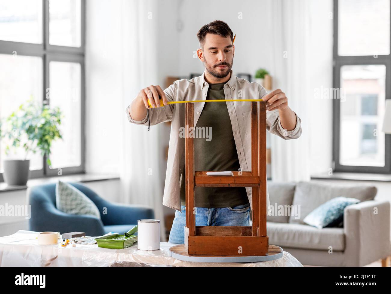 man with ruler measuring table for renovation Stock Photo - Alamy