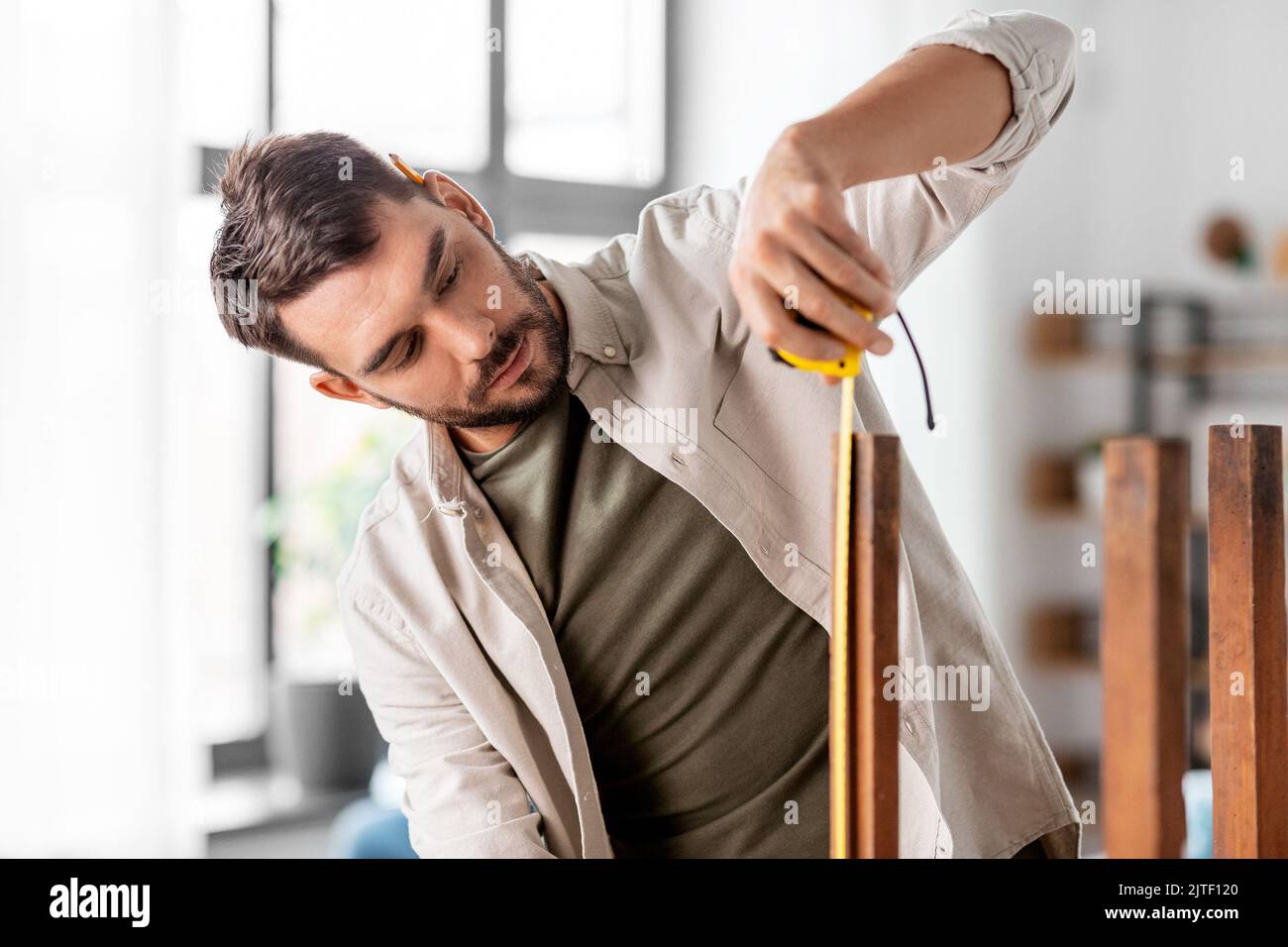 man with ruler measuring table for renovation Stock Photo - Alamy