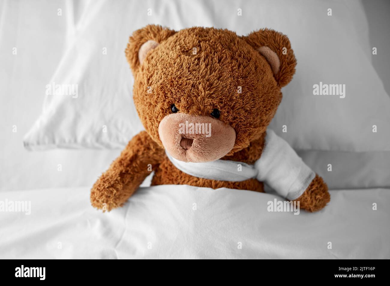ill teddy bear toy with bandaged paw in bed Stock Photo - Alamy