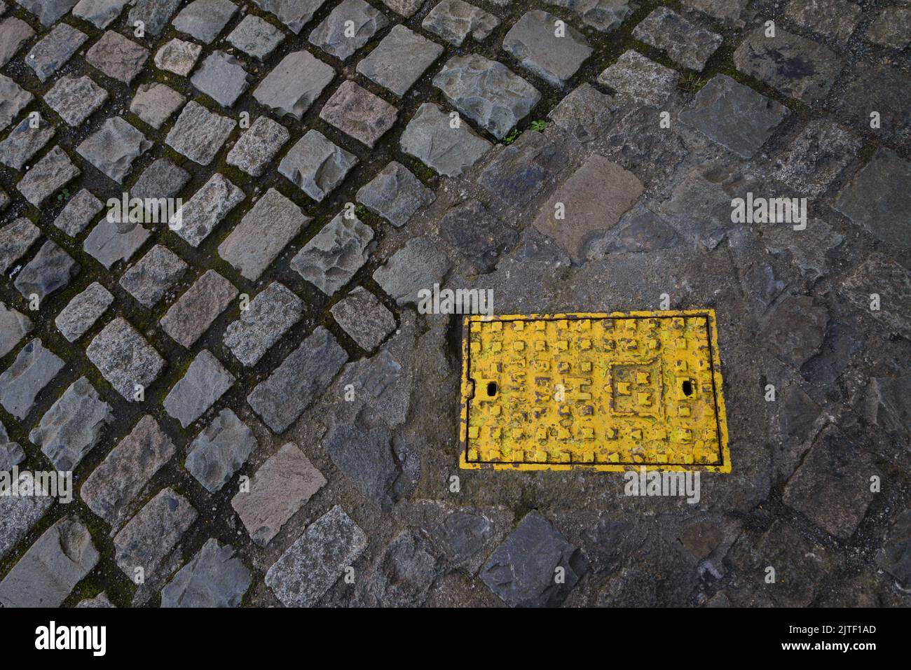 Gray brick road in Dublin, Ireland with yellow textured cover in right ...