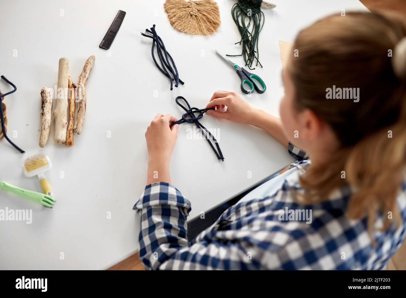 woman making macrame and knotting cords Stock Photo - Alamy