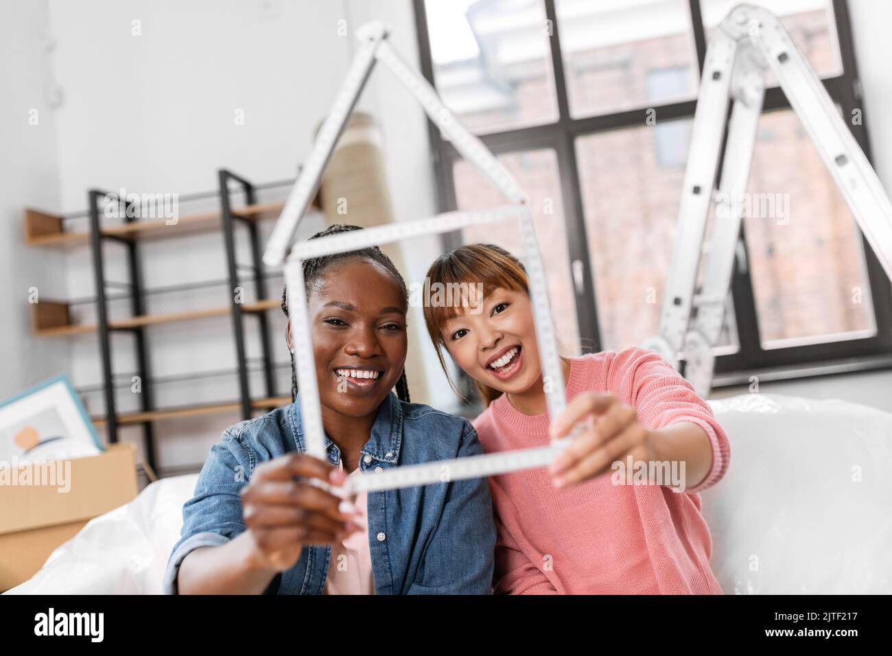 happy smiling women with ruler in shape of house Stock Photo - Alamy