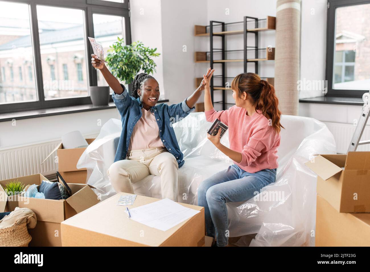 happy women moving to new home and counting money Stock Photo - Alamy