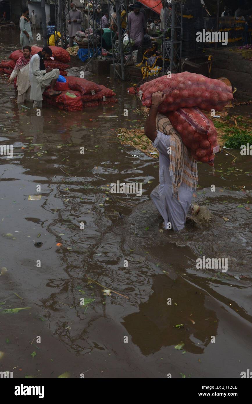 Pakistani people on their way and busy in Badami bagh vegetable market during heavy monsoon ...