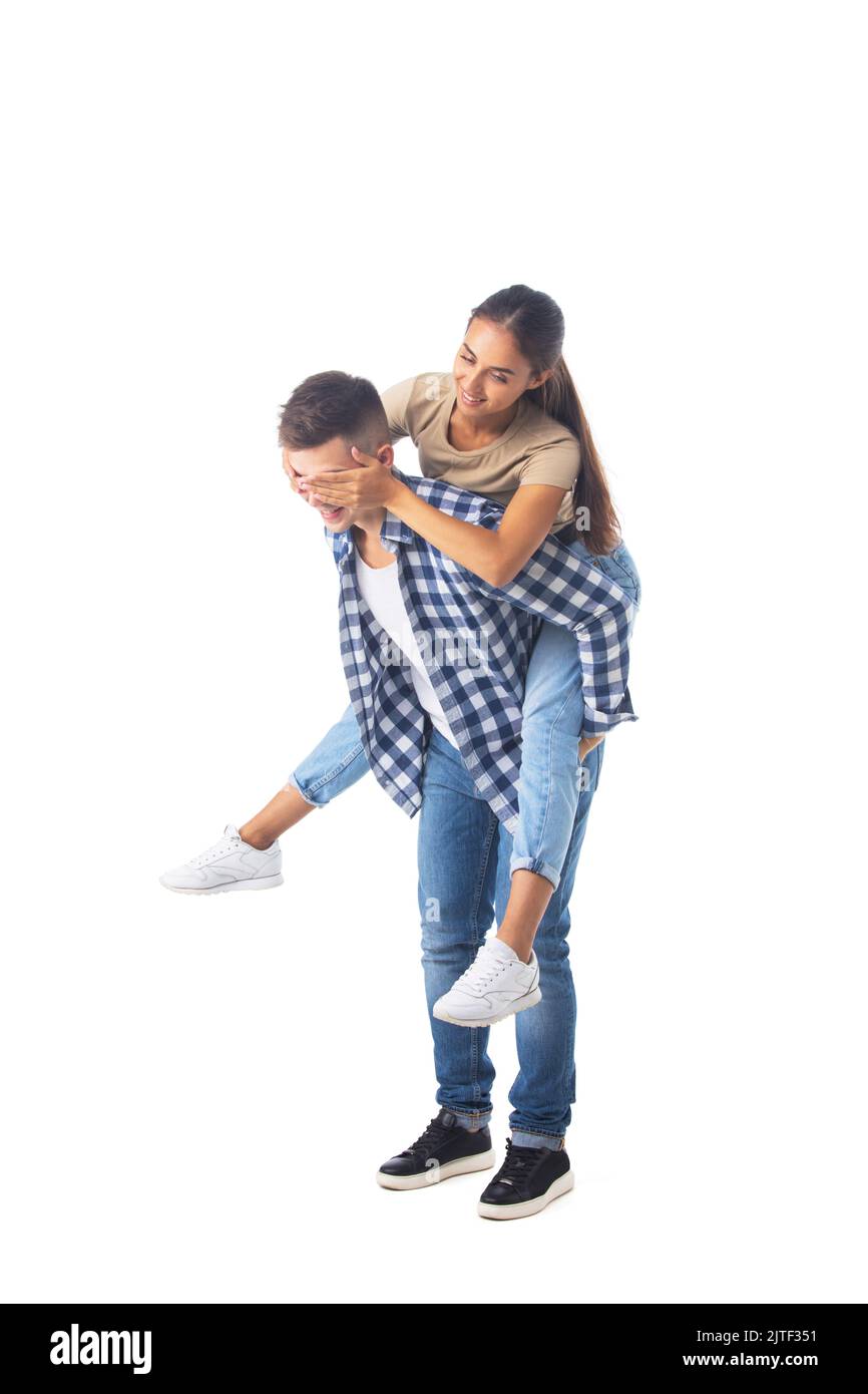Young male carrying his girlfriend piggyback isolated on white ...