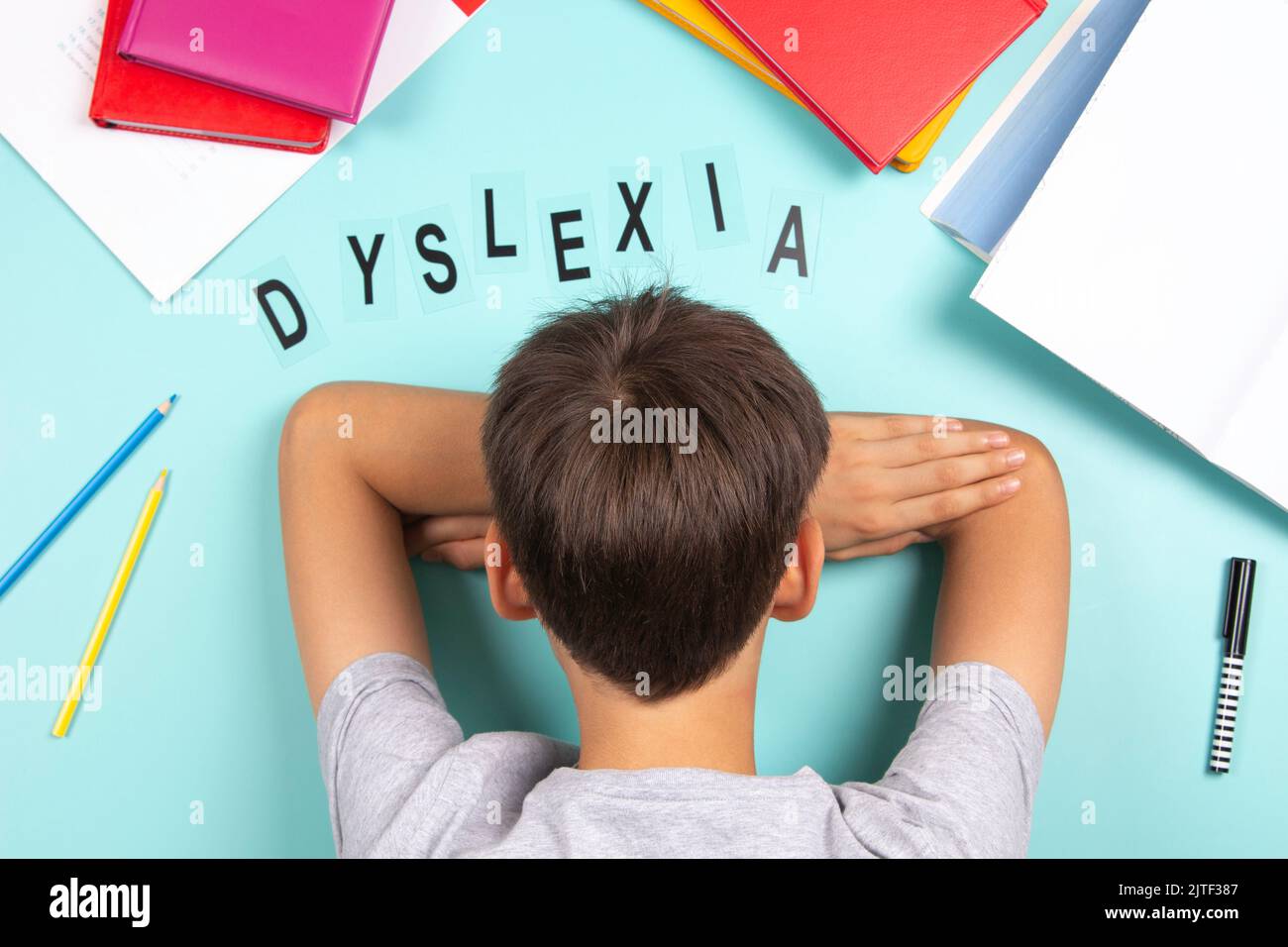 Sad tired frustrated boy lies on the table with many books. Word ...