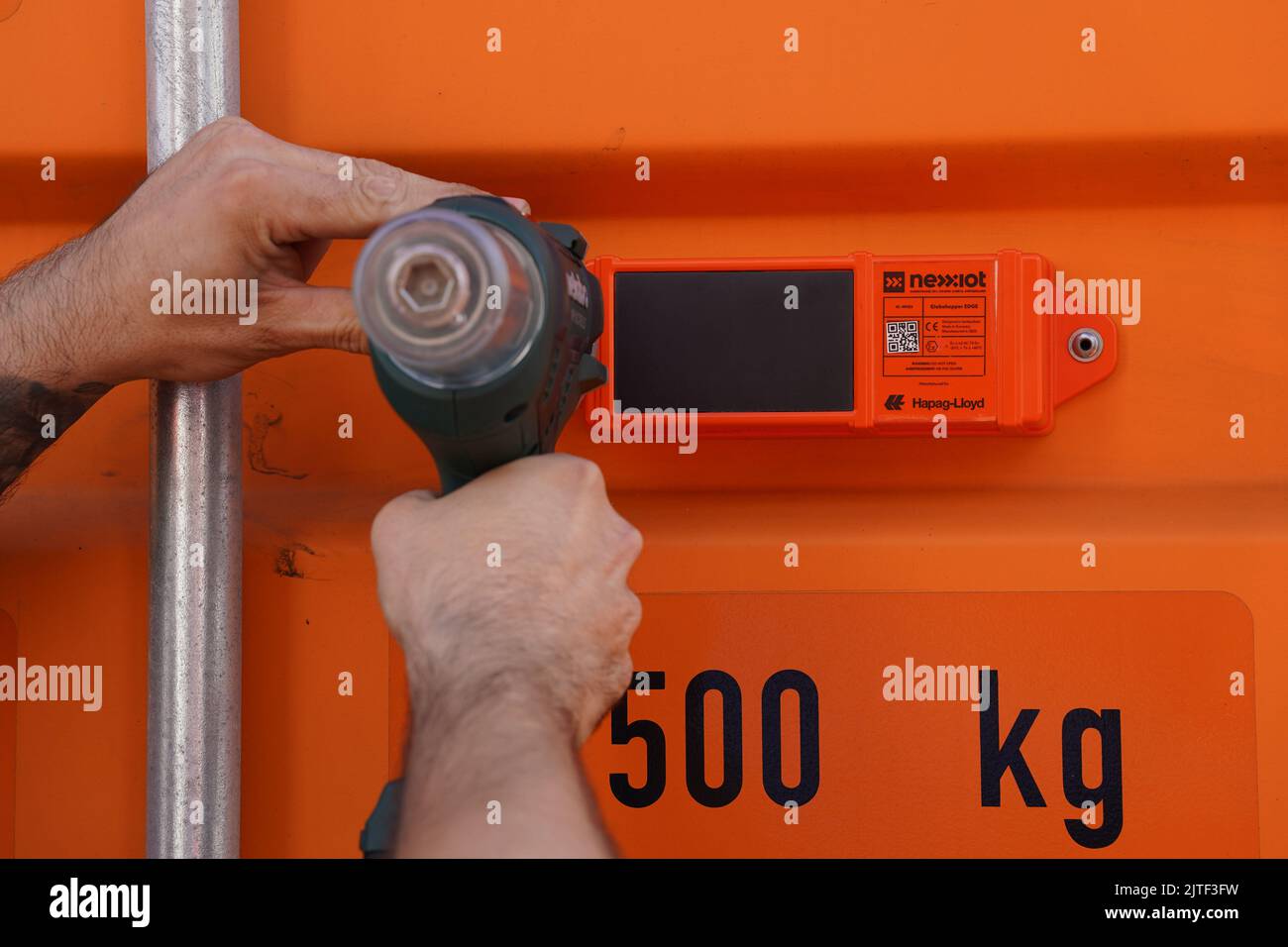 30 August 2022, Hamburg: Employee Marius Paluch attaches a live tracking device to a Hapag-Lloyd ...