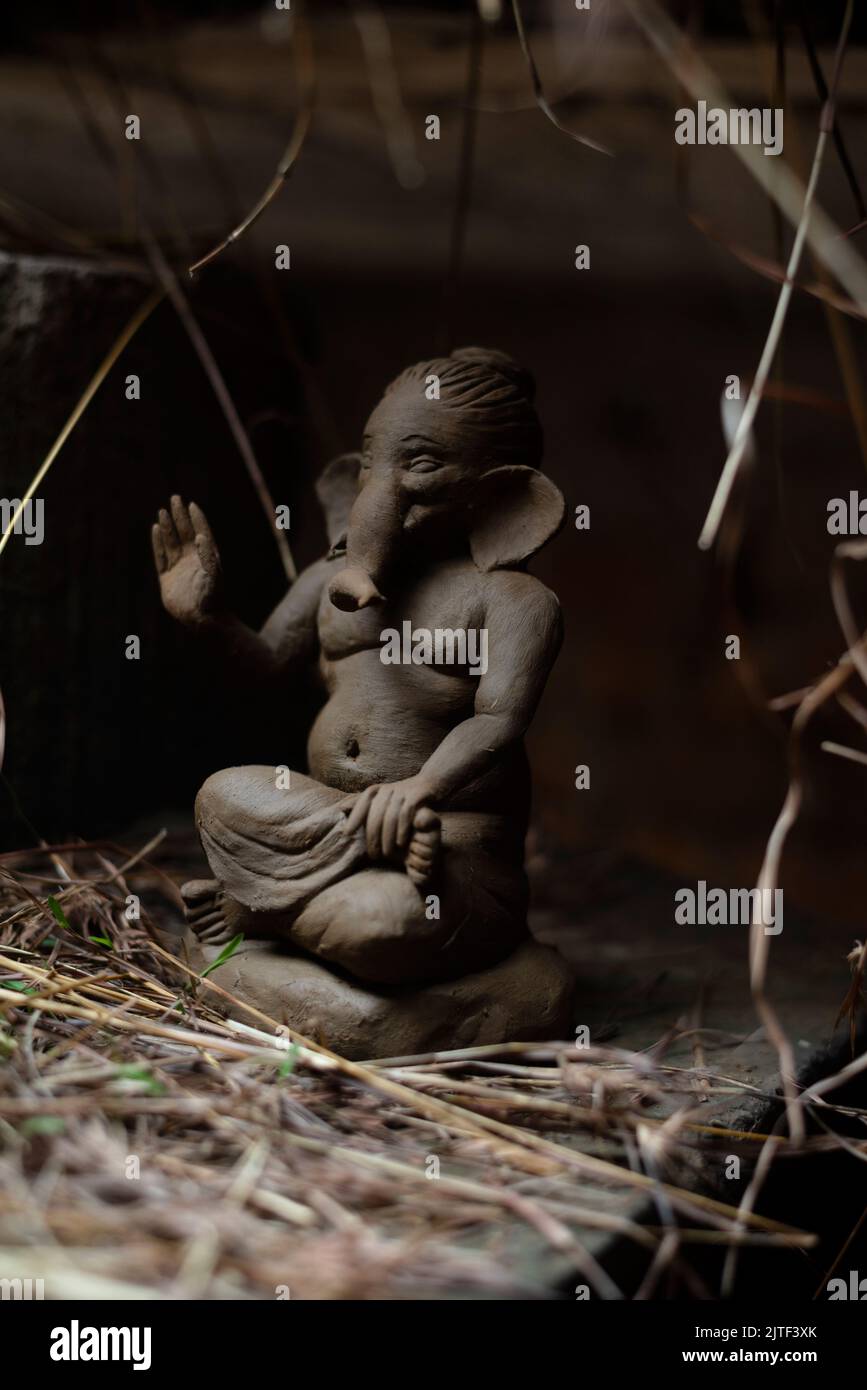 Unfinished, uncolored clay model of lord ganesha kept on the floor ...