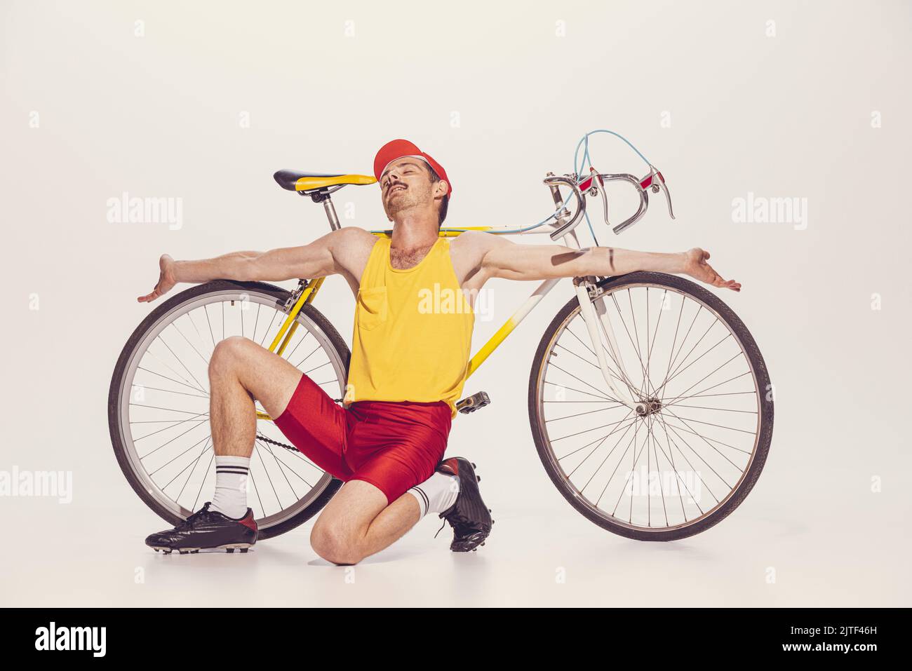 Portrait of young man in colorful clothes, uniform leaning on bike and ...