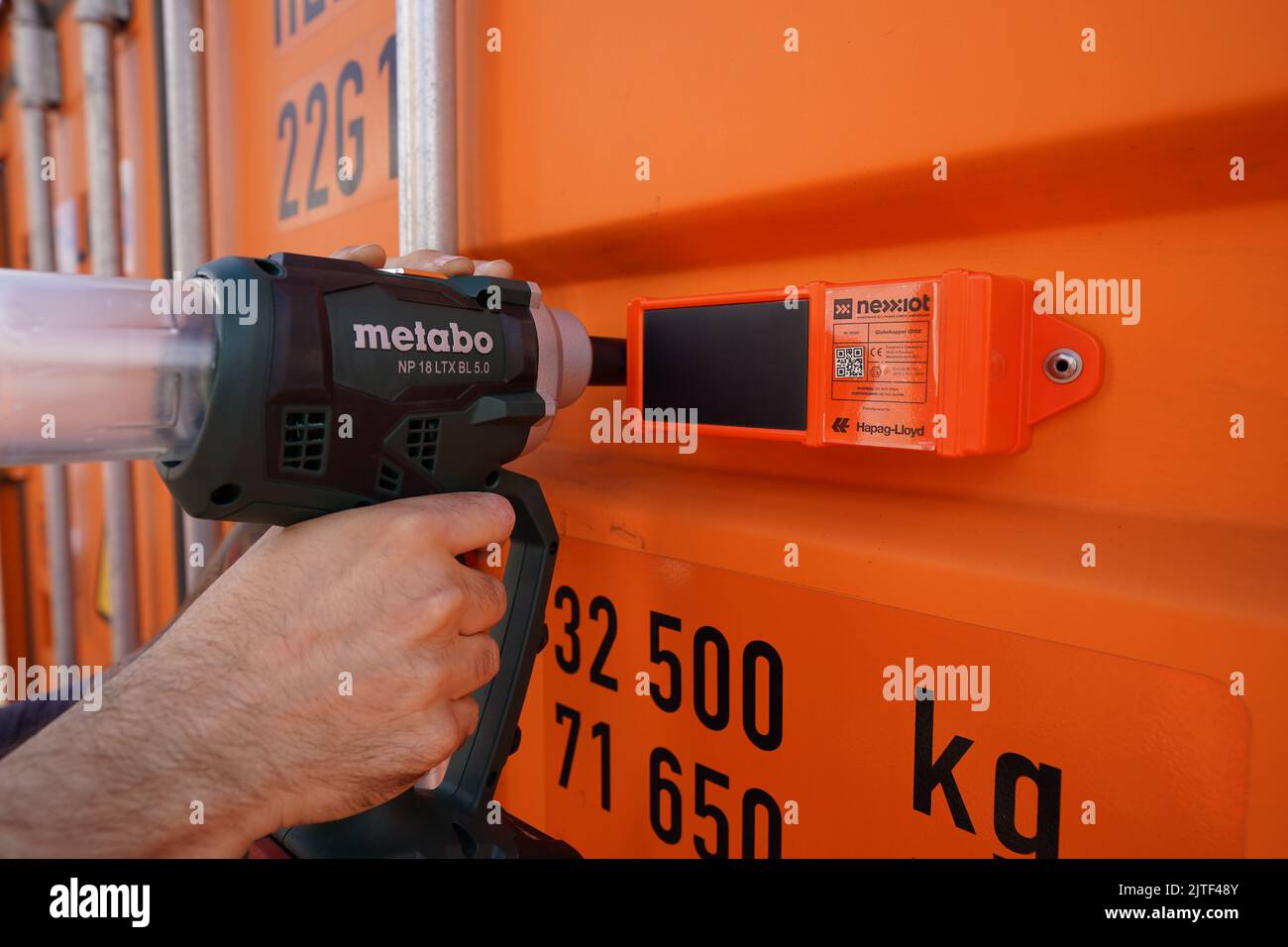 30 August 2022, Hamburg: An employee attaches a live tracking device to ...