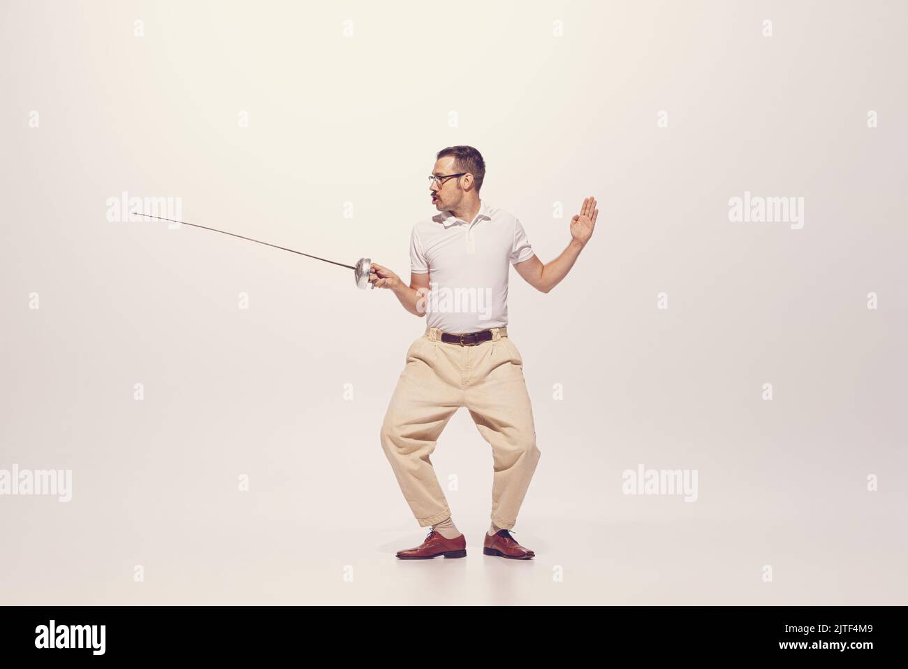 Portrait of man in a suit posing, fighting with swords in a jump ...