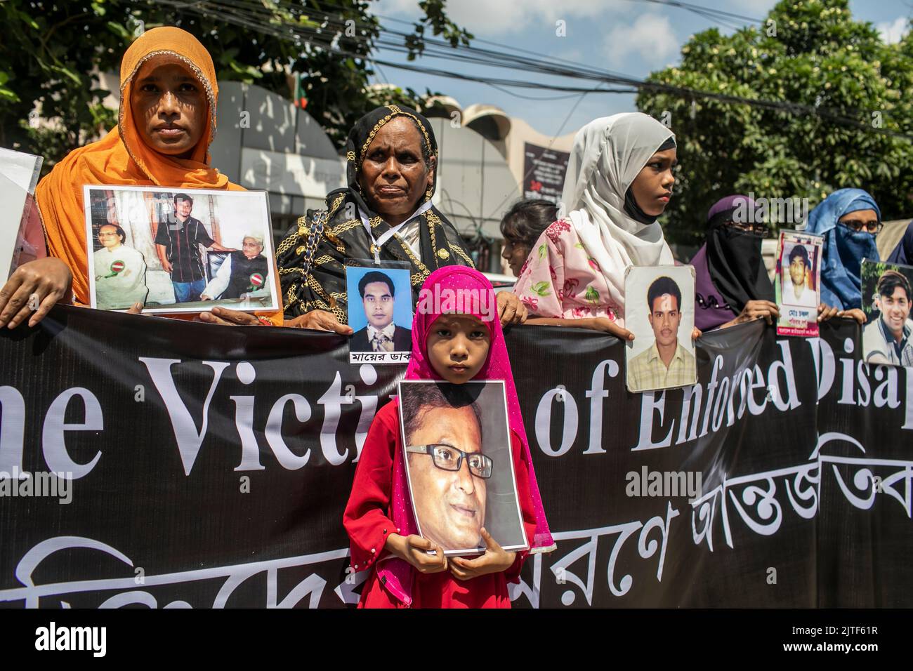 Dhaka, Bangladesh. 30th Aug, 2022. A kid and women hold pictures of their missing relatives ...