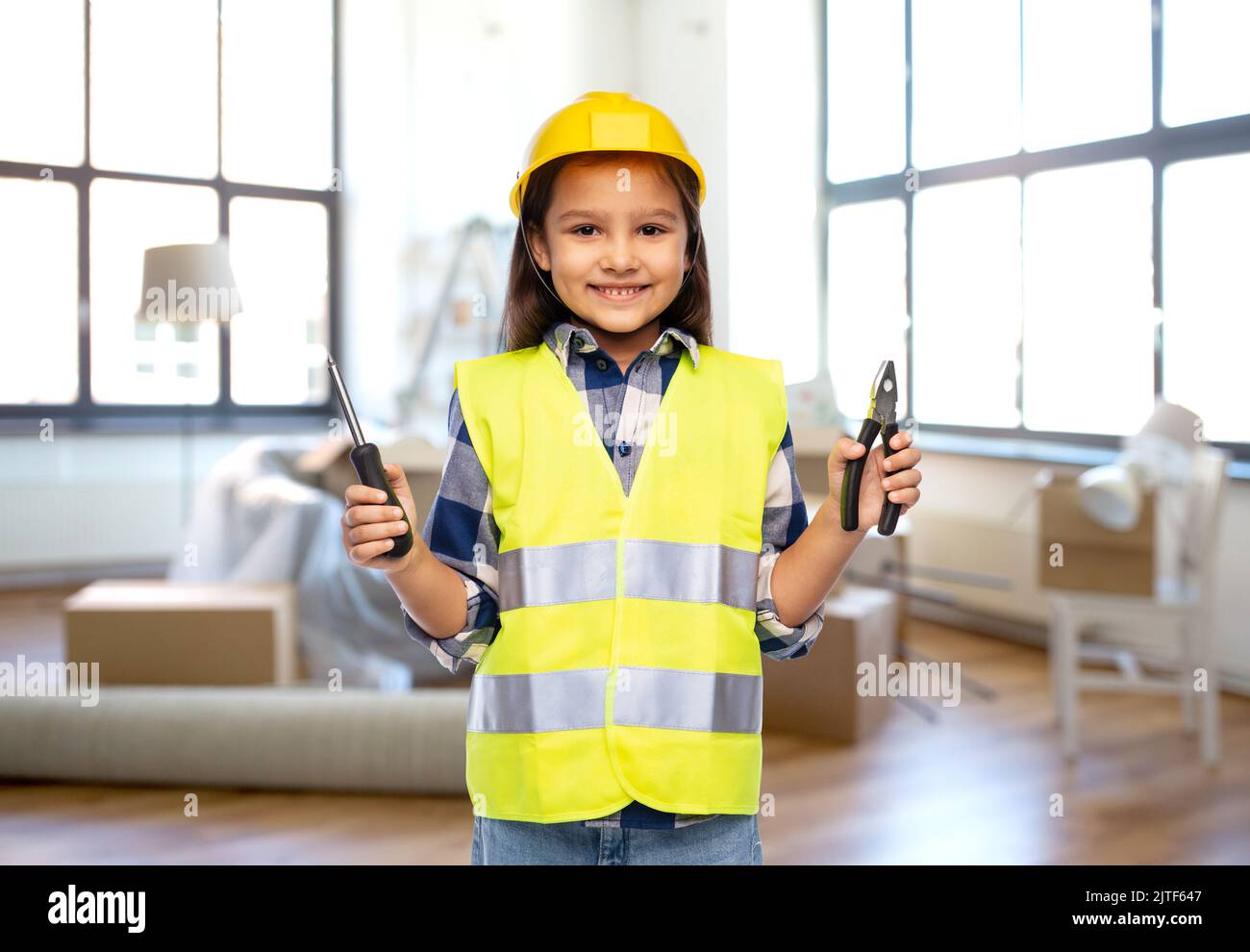 little girl in helmet and safety vest with tools Stock Photo - Alamy