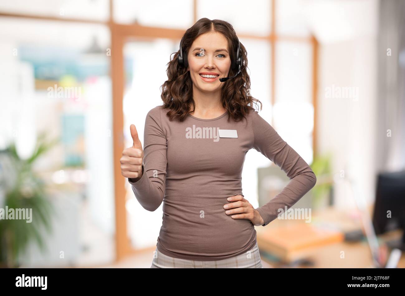 helpline operator showing thumbs up at office Stock Photo - Alamy