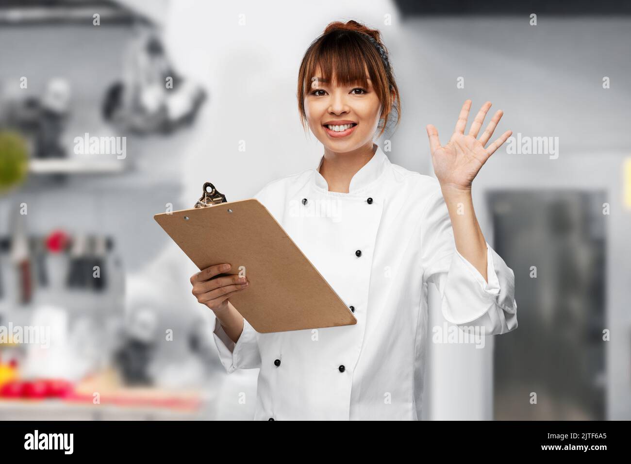 female chef with clipboard waving hand on kitchen Stock Photo - Alamy