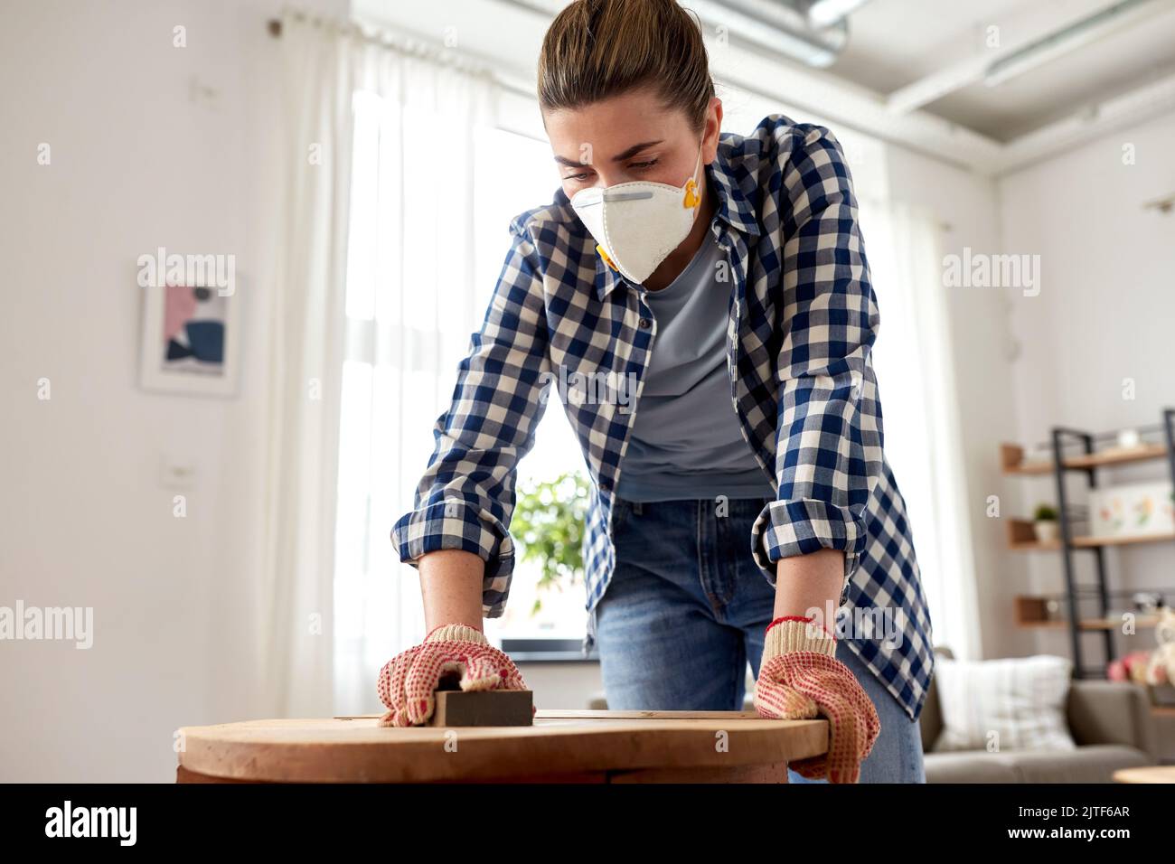 woman in respirator sanding old table with sponge Stock Photo - Alamy