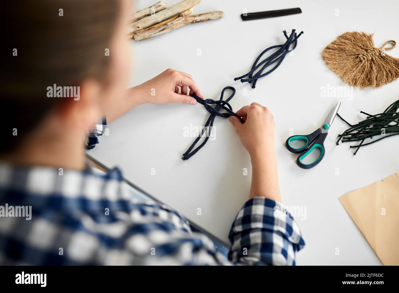 woman making macrame and knotting cords Stock Photo - Alamy