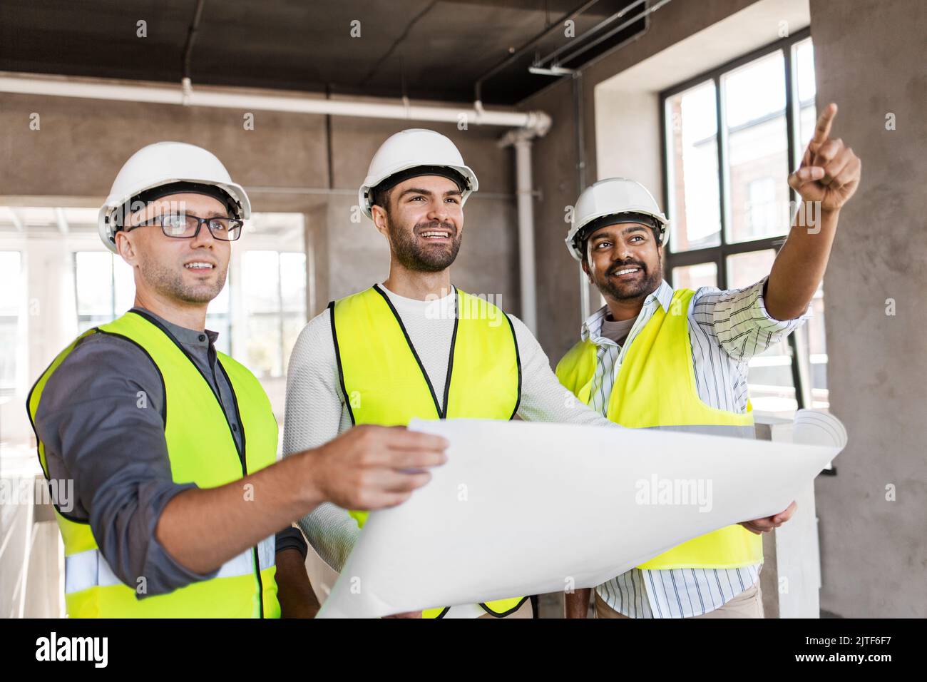 architects in helmets with blueprint at office Stock Photo - Alamy