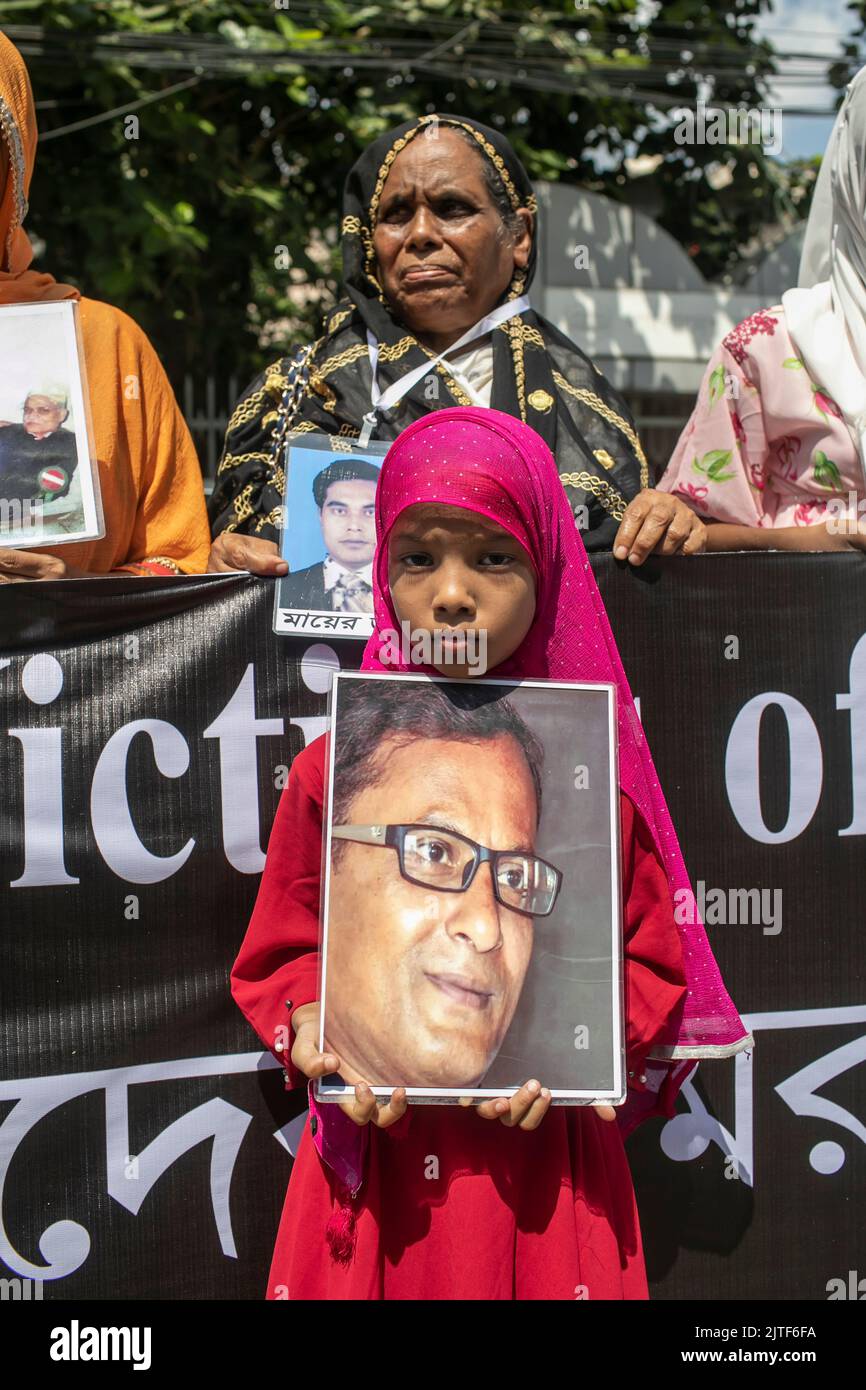 Dhaka, Bangladesh. 30th Aug, 2022. A kid holds a picture of her missing father during the ...