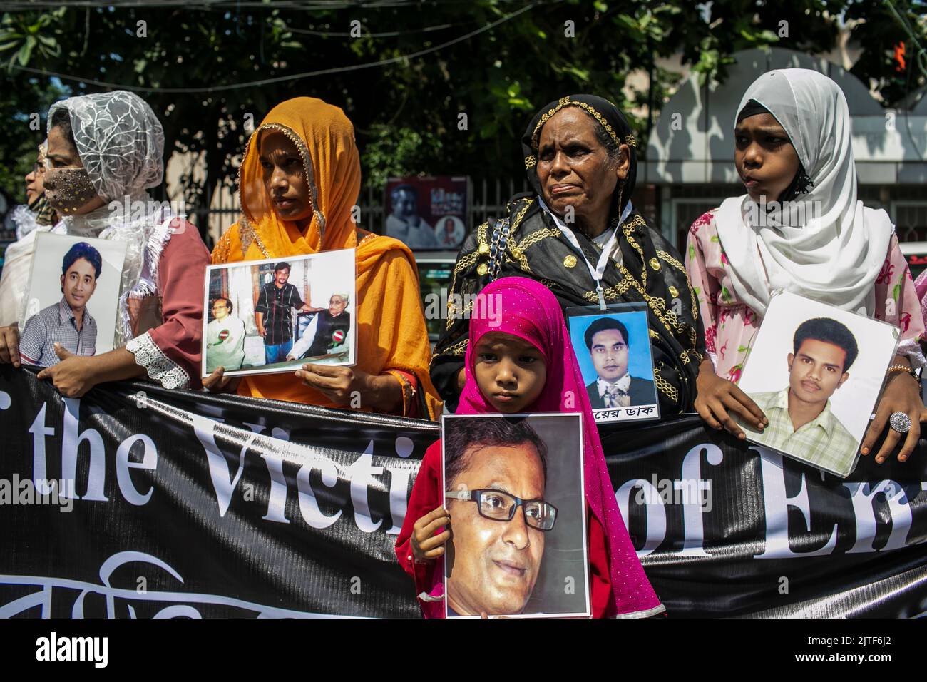 Dhaka, Bangladesh. 30th Aug, 2022. A kid and women hold pictures of their missing relatives ...