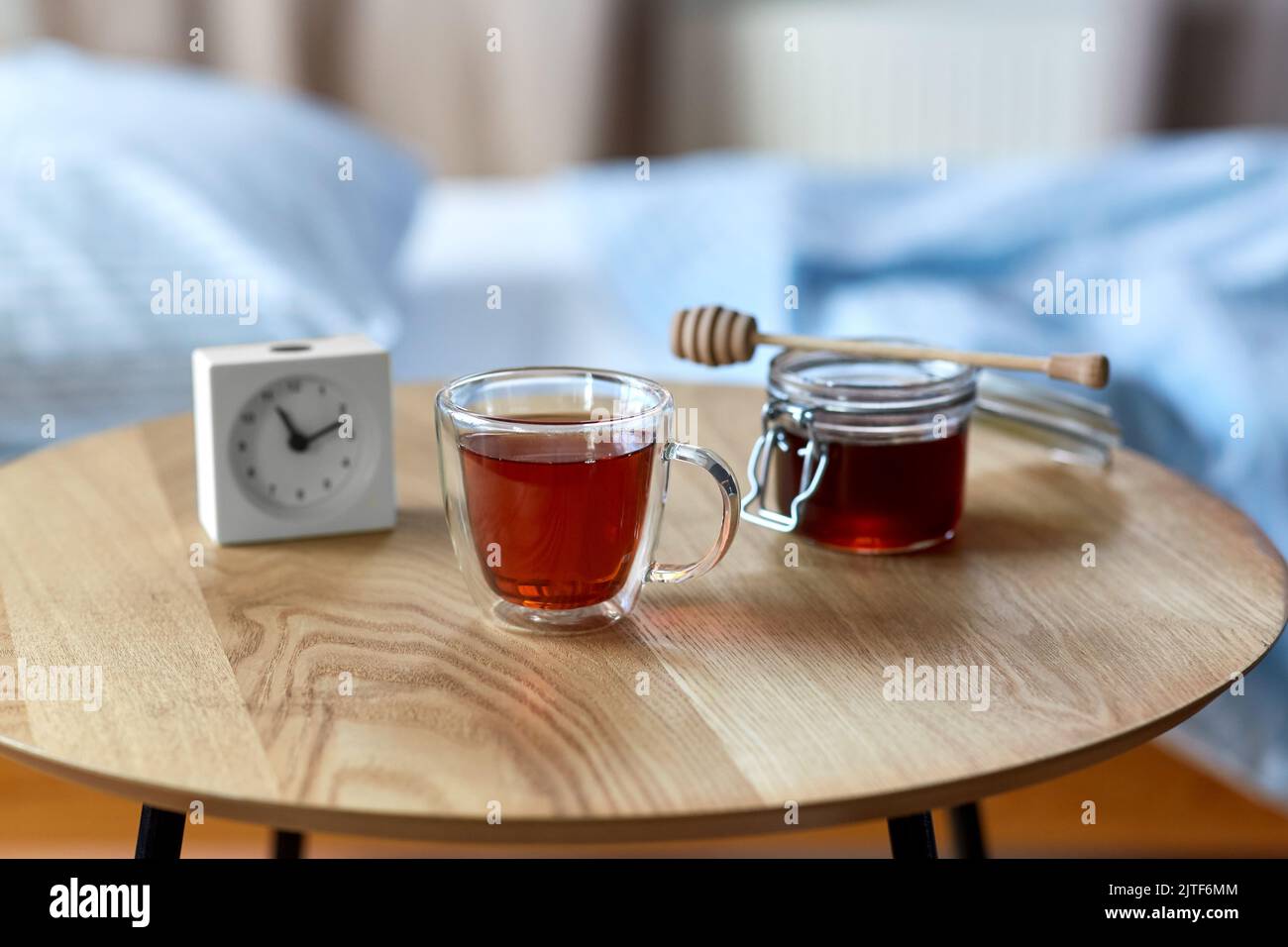 cup of tea, honey and alarm clock on table Stock Photo - Alamy