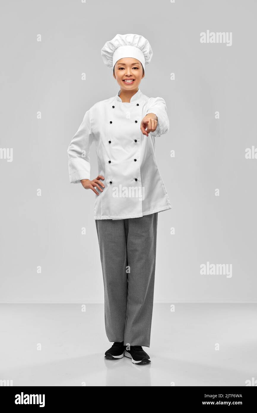 smiling female chef pointing finger to sonething Stock Photo - Alamy