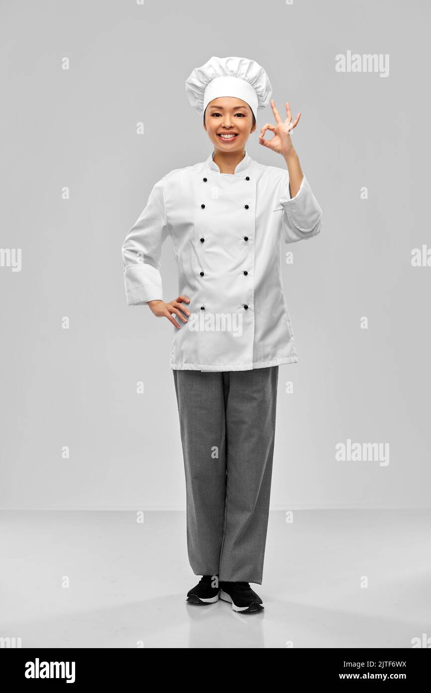 happy smiling female chef showing ok hand sign Stock Photo - Alamy