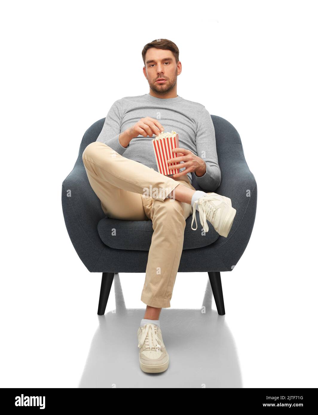 bored man eating popcorn sitting in chair Stock Photo - Alamy