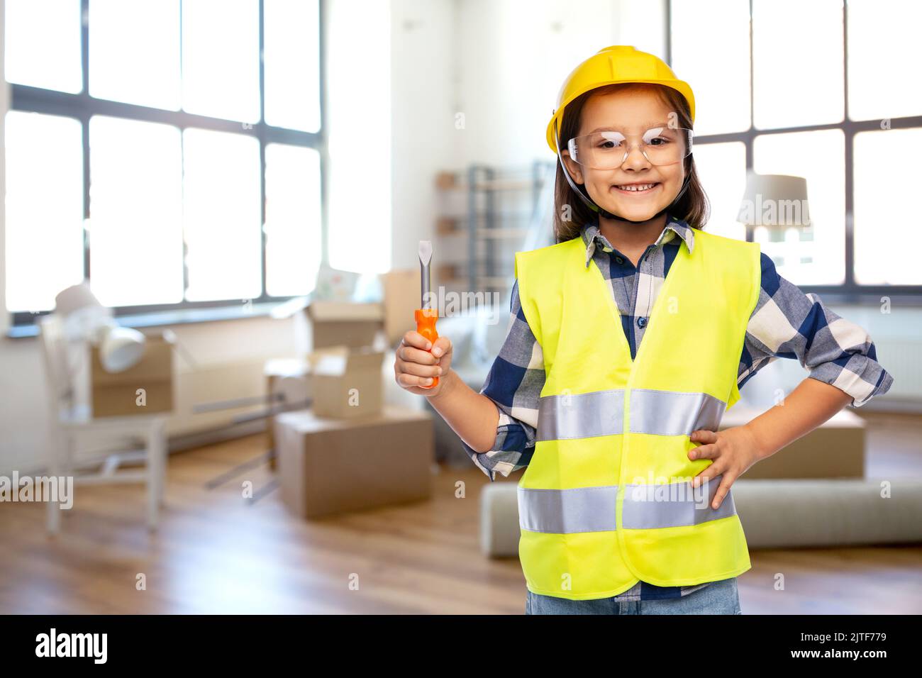 girl in helmet and safety vest with screwdriver Stock Photo - Alamy