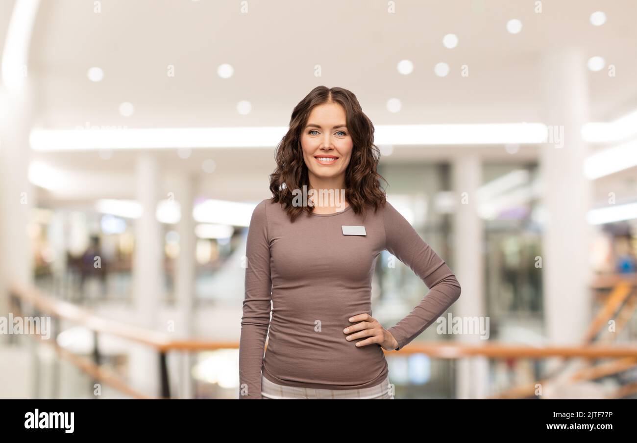 happy female shop assistant with name tag at mall Stock Photo - Alamy
