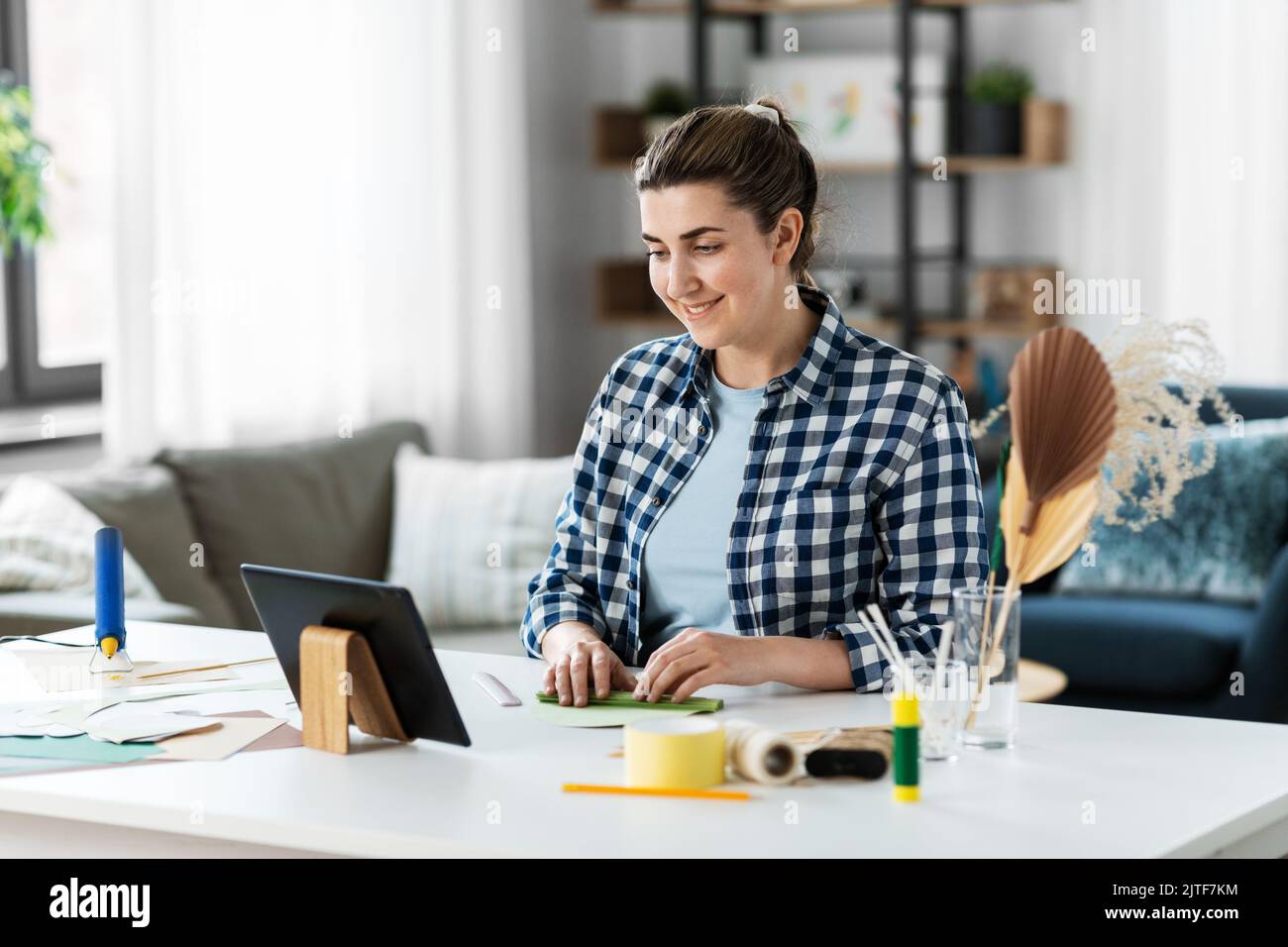 woman with tablet pc making paper craft at home Stock Photo - Alamy