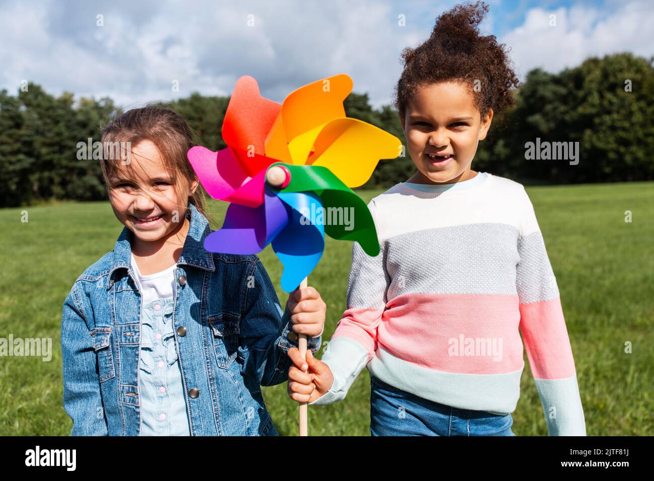 happy girls with pinwheel having fun at park Stock Photo - Alamy