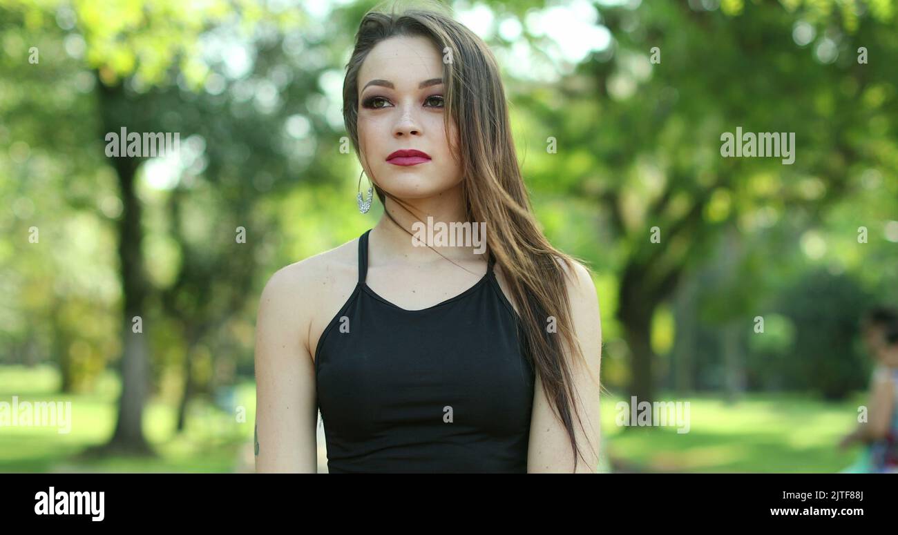 Pretty beautiful millennial girl standing in outdoor park Stock Photo ...
