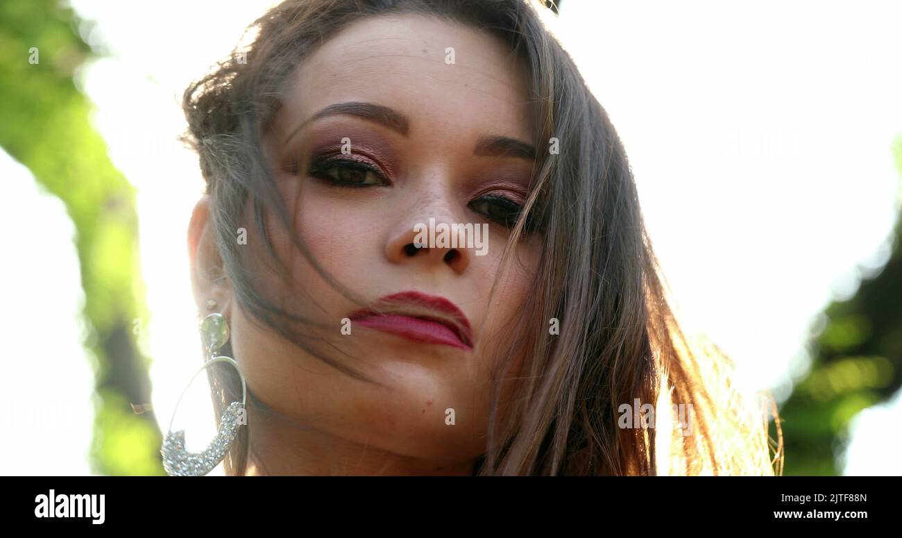 Pretty girl face in outdoors with lens-flare sunlight flaring. Portrait ...