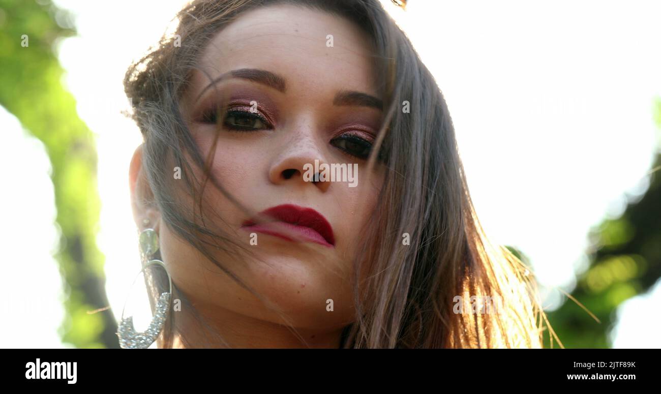 Pretty girl face in outdoors with lens-flare sunlight flaring. Portrait ...