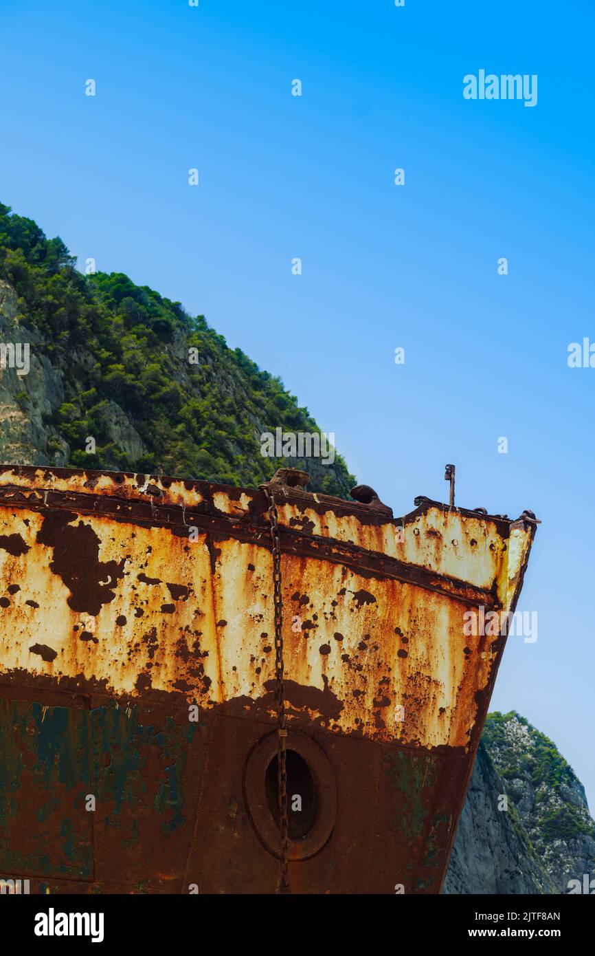 Day low angle view of abandoned rusted shipwreck with bow visible at ...