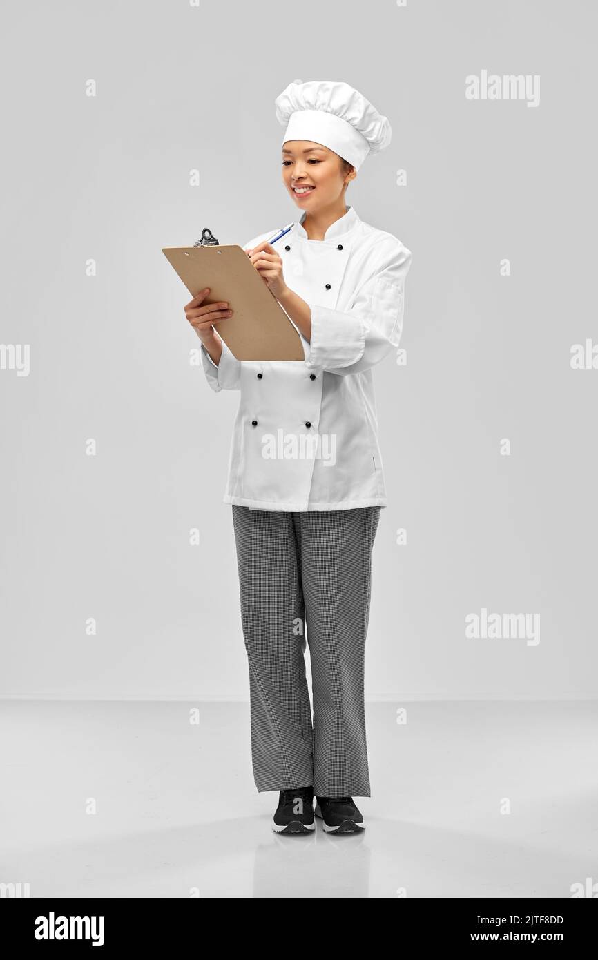smiling female chef with clipboard and pen Stock Photo - Alamy