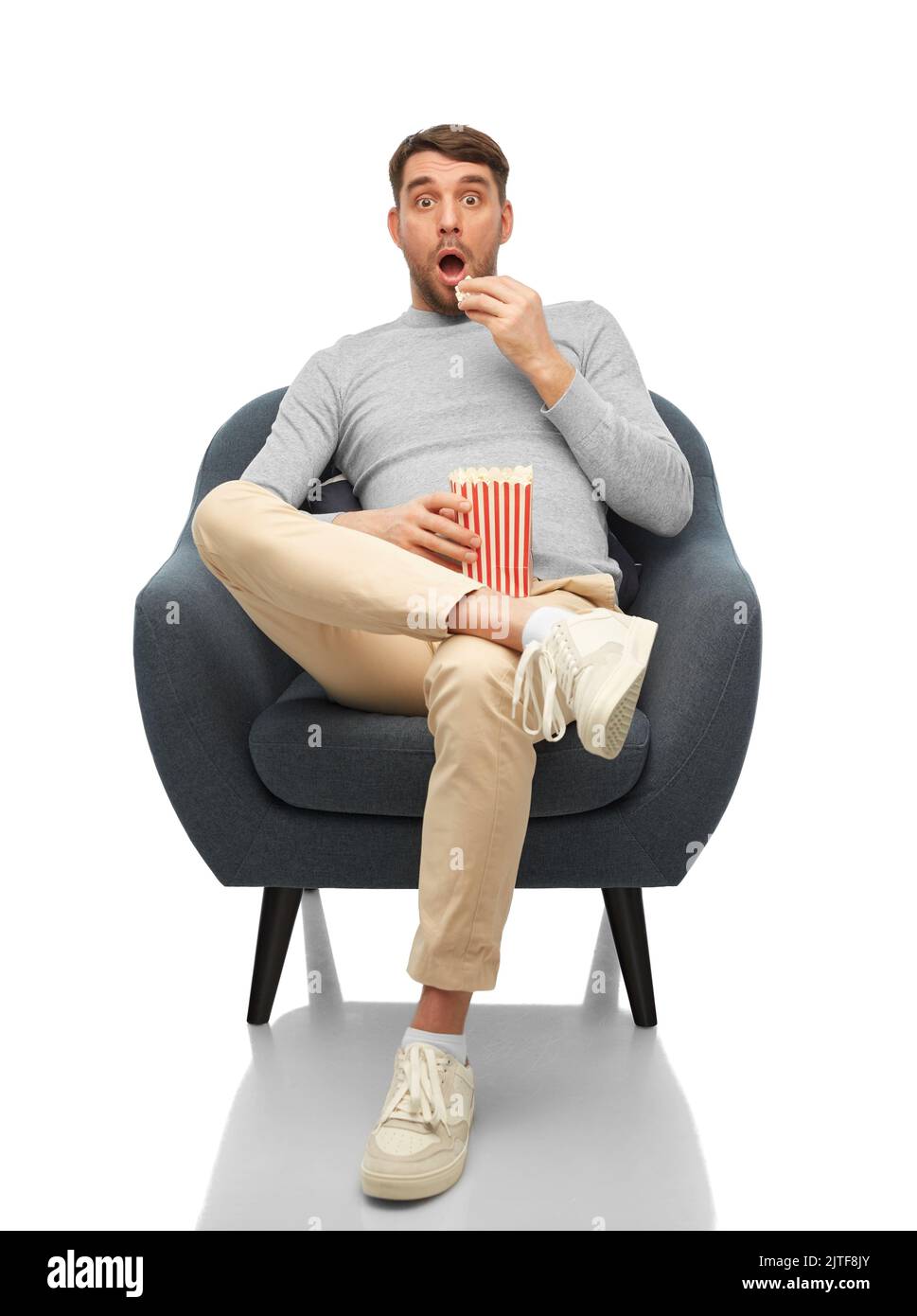 surprised man eating popcorn sitting in chair Stock Photo - Alamy