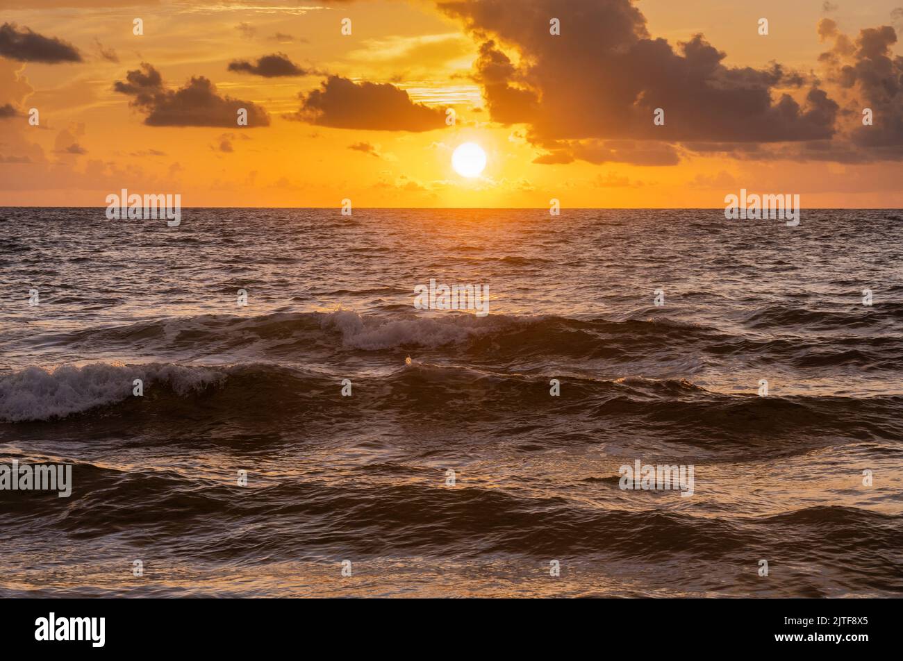 Sun rising over ocean Stock Photo - Alamy