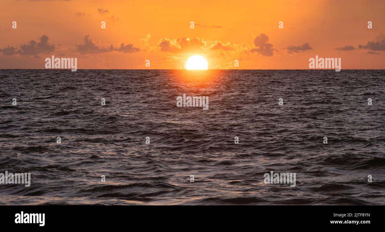 Sun rising over ocean Stock Photo - Alamy