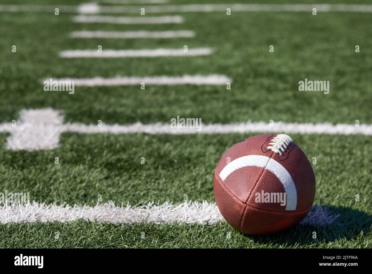 American football ball at yard line markers on playing field Stock ...